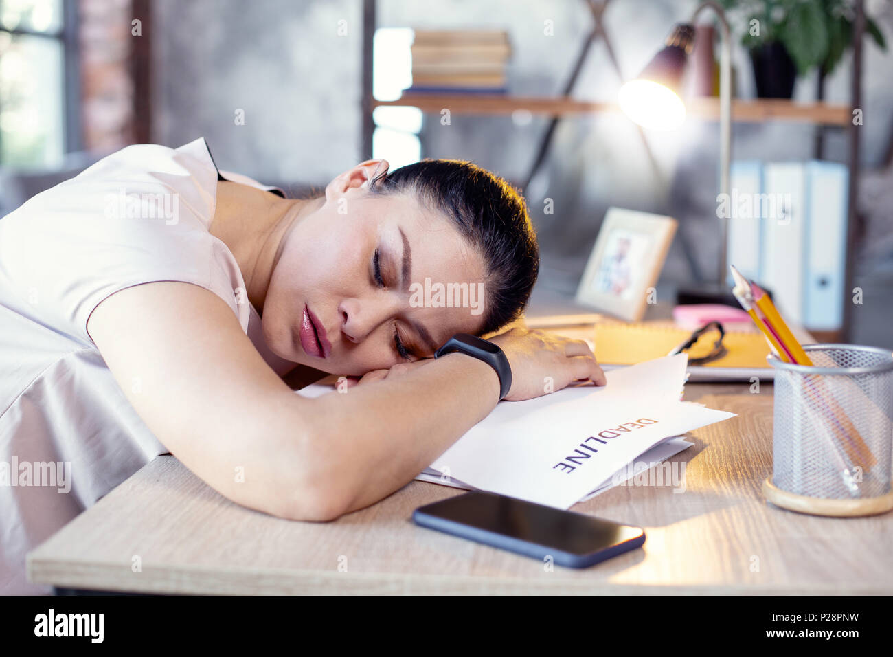 Beautiful female employee taking nap at work Stock Photo - Alamy