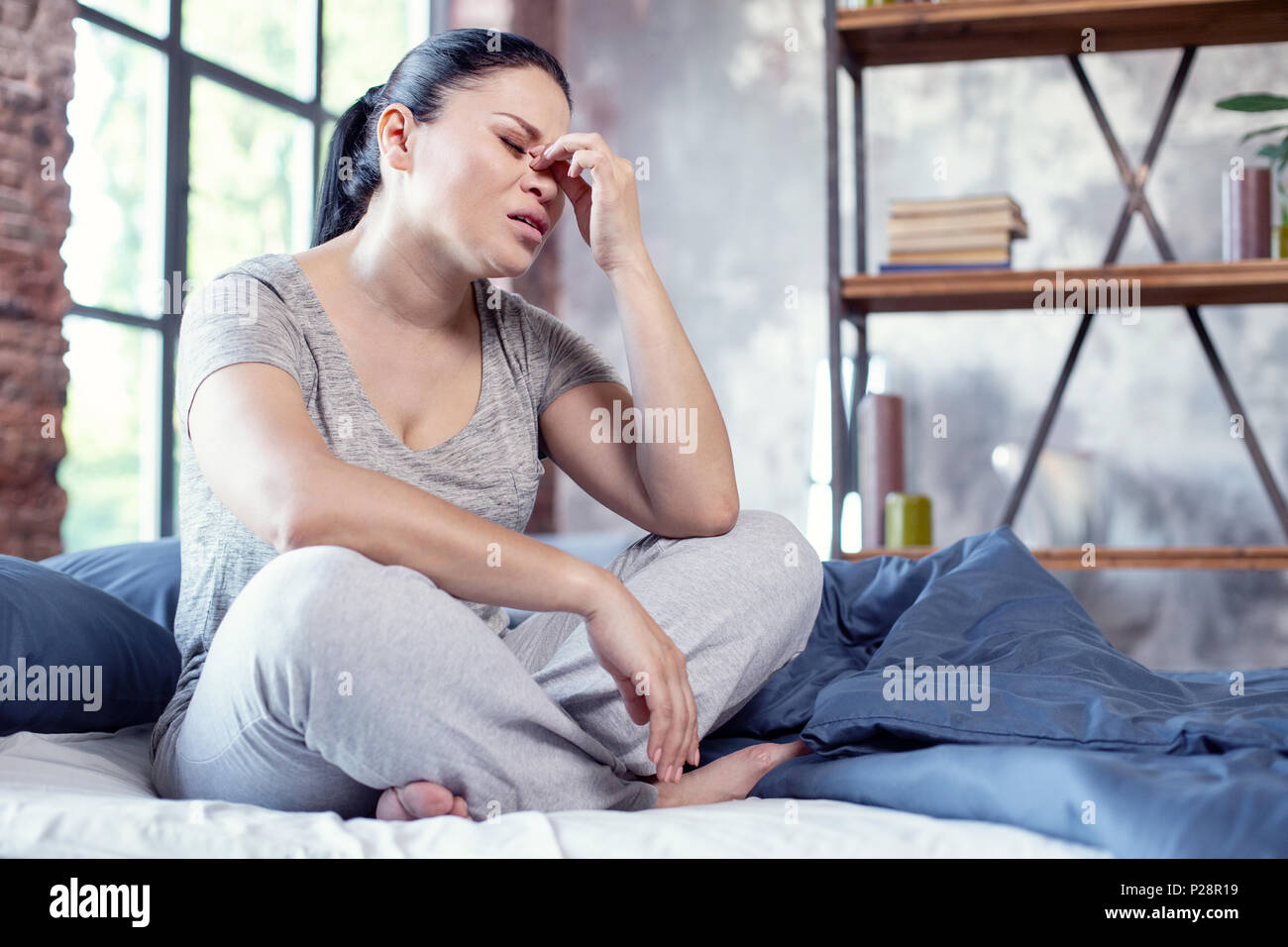 Dull sad woman relieving migraine Stock Photo - Alamy