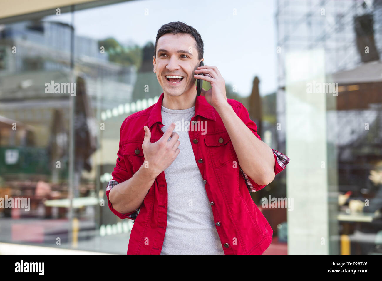 Stylish man wearing red jacket speaking on the phone Stock Photo - Alamy