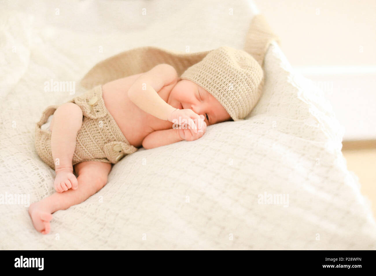 Newborn baby sleeping and wearing crocheted clothes Stock Photo - Alamy