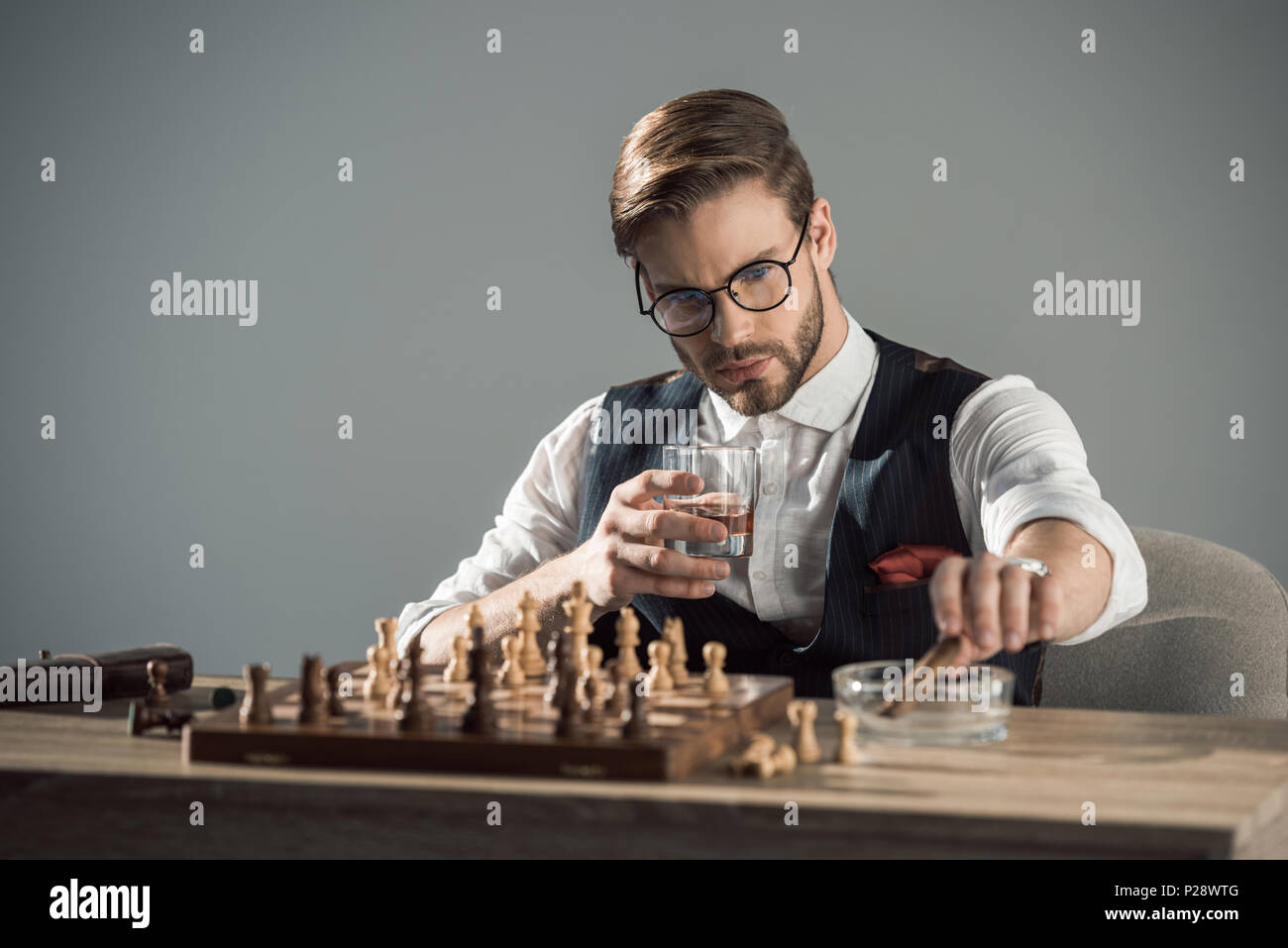 young businessman with glass of whisky and cigar playing chess Stock ...