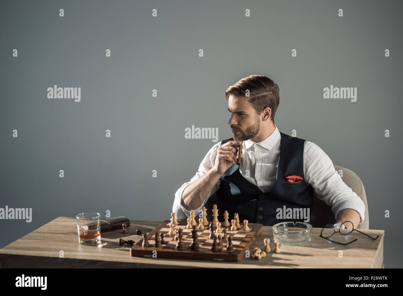 young man smoking cigar and looking away while playing chess Stock ...