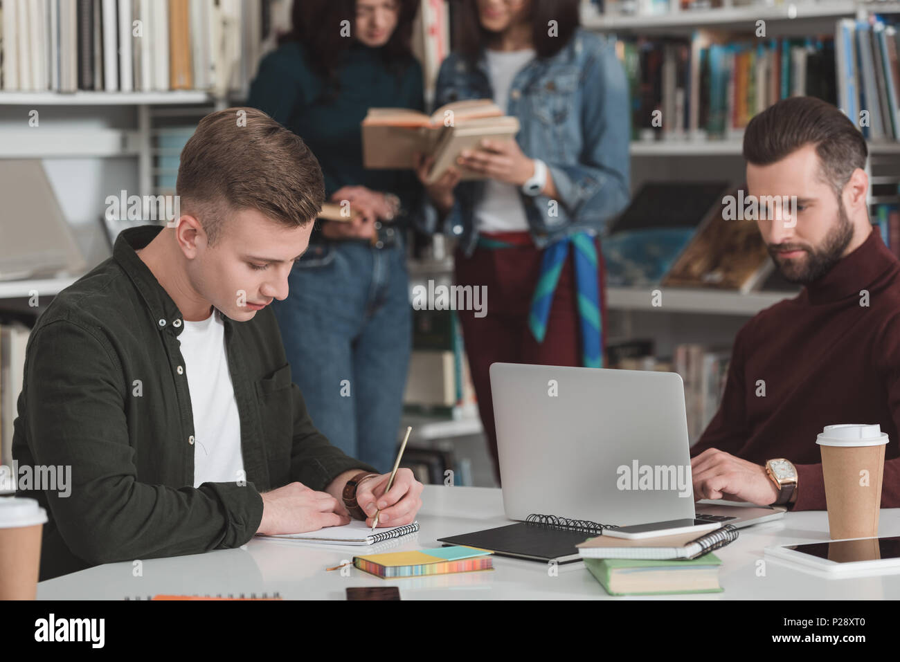 male students studying in library with laptop Stock Photo - Alamy