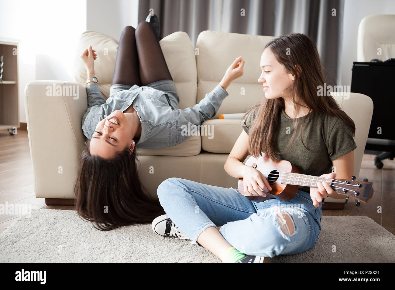 Two sisters in the living room having fun Stock Photo - Alamy