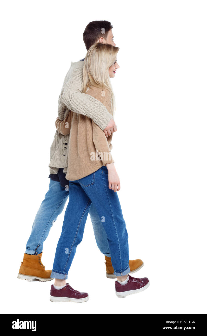 Side view of going couple. walking friendly girl and guy holding hands ...