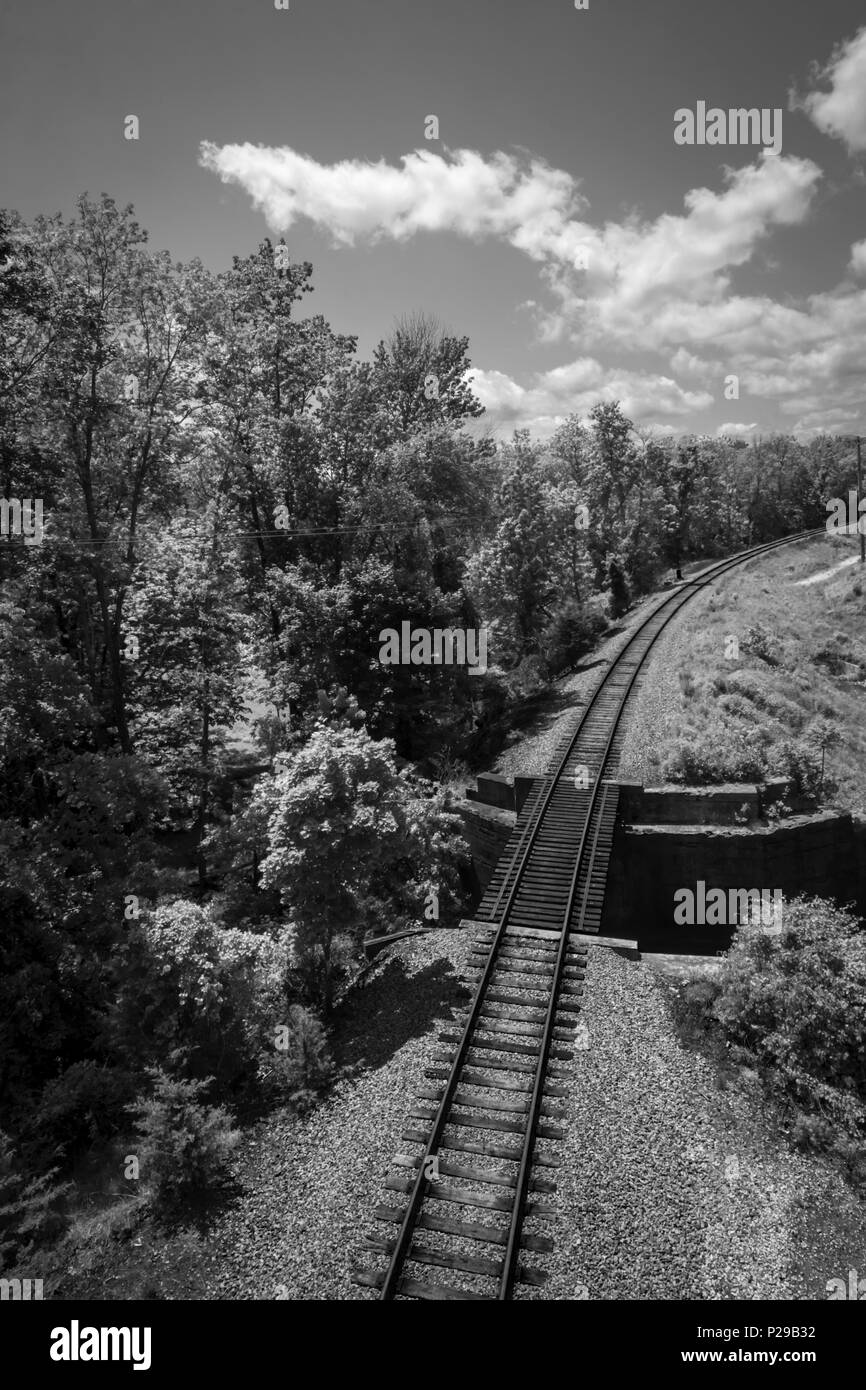 Black and white train tracks beside bridge landscape Stock Photo - Alamy