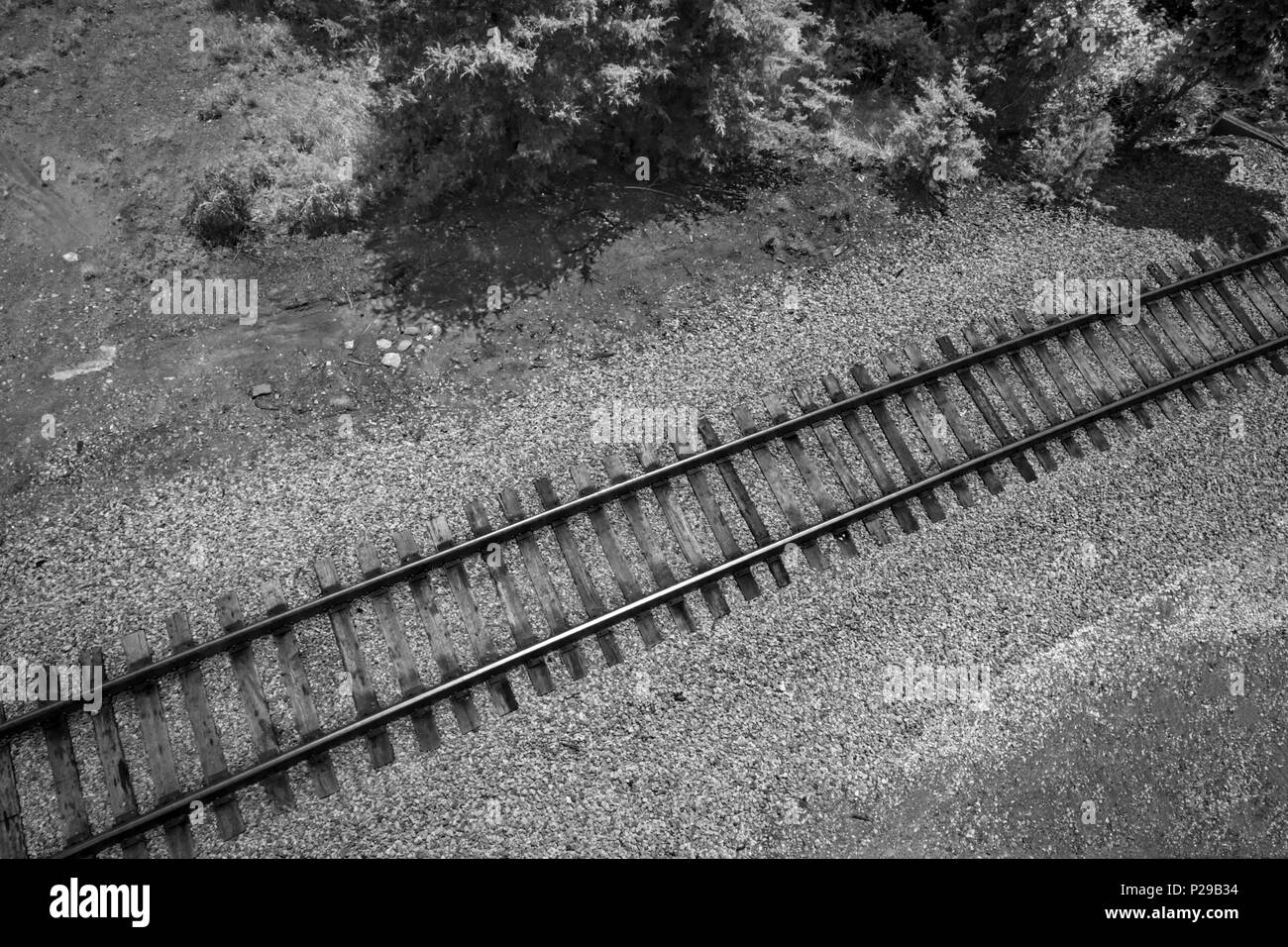 Black and white train tracks beside bridge landscape Stock Photo - Alamy