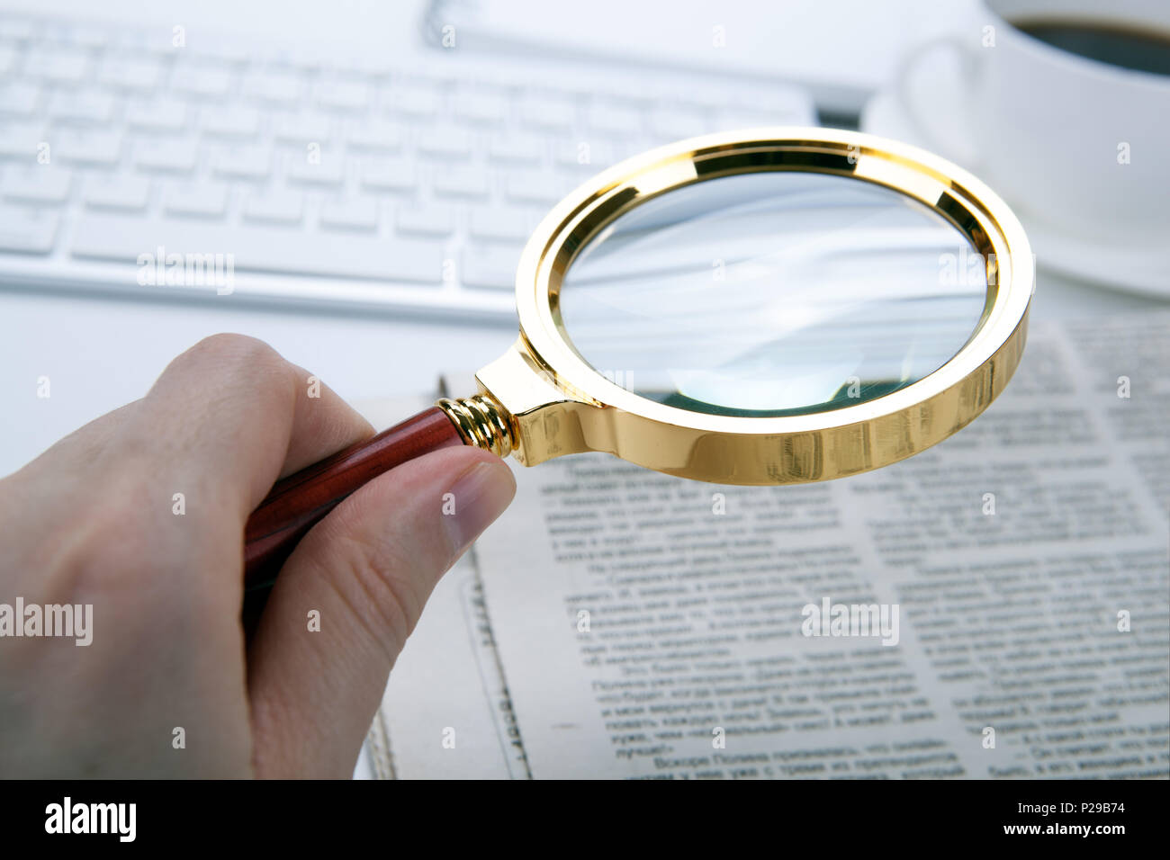 man's hand holds a magnifying glass over a newspaper font Stock Photo ...