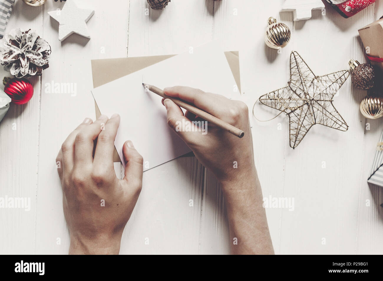 hands holding pencil and writing a letter to santa claus with space for ...