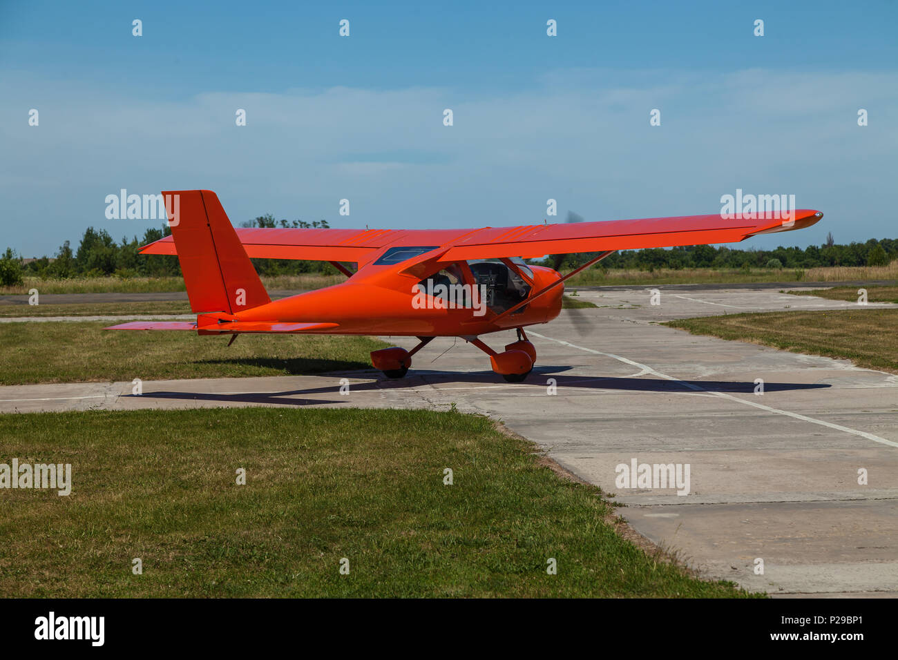 Light aircraft of a red color on a private airfield to prepare for the ...