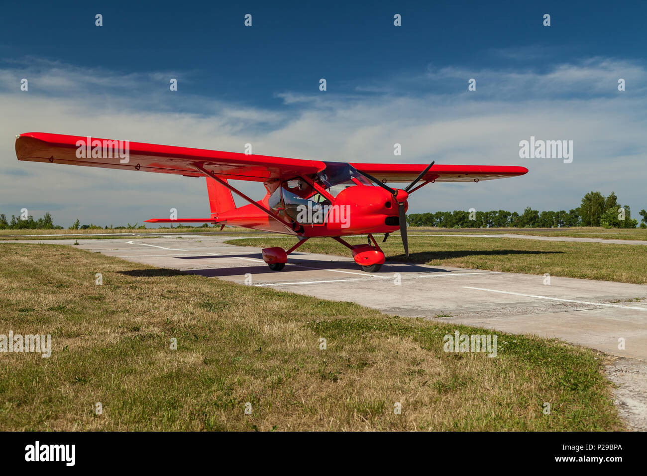 Light aircraft of a red color on a private airfield to prepare for the ...
