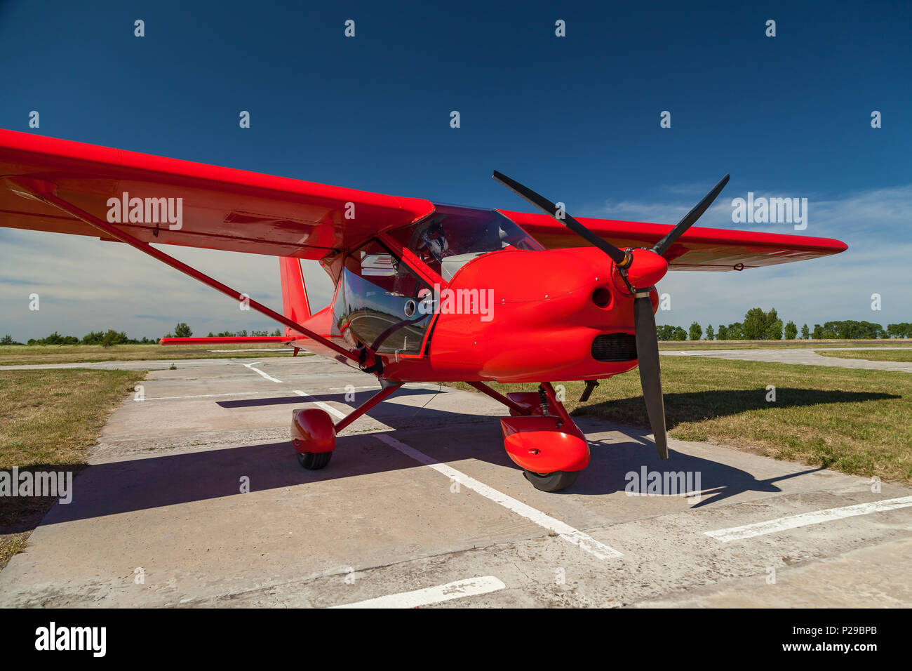 Light aircraft of a red color on a private airfield to prepare for the ...