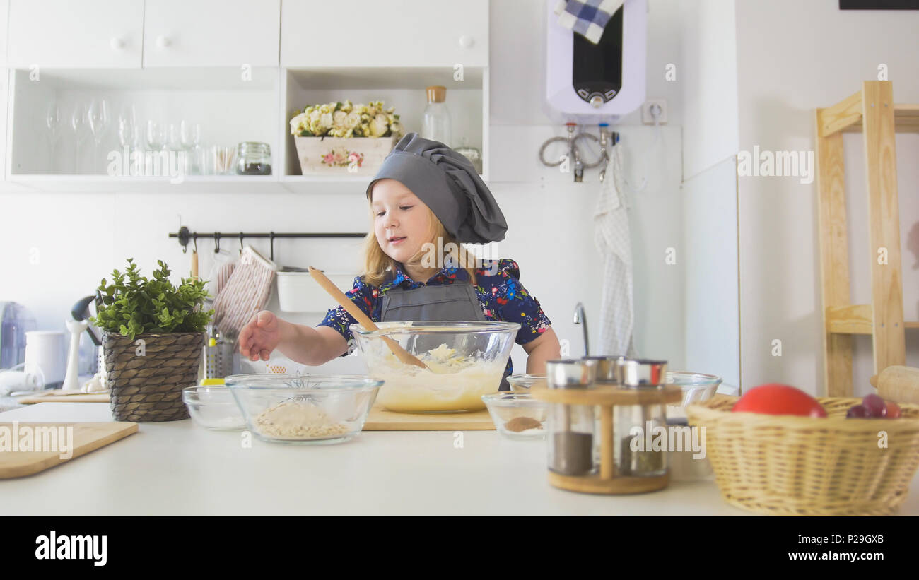 Cute little girl chef pointed hand on bowls with ingredients for ...