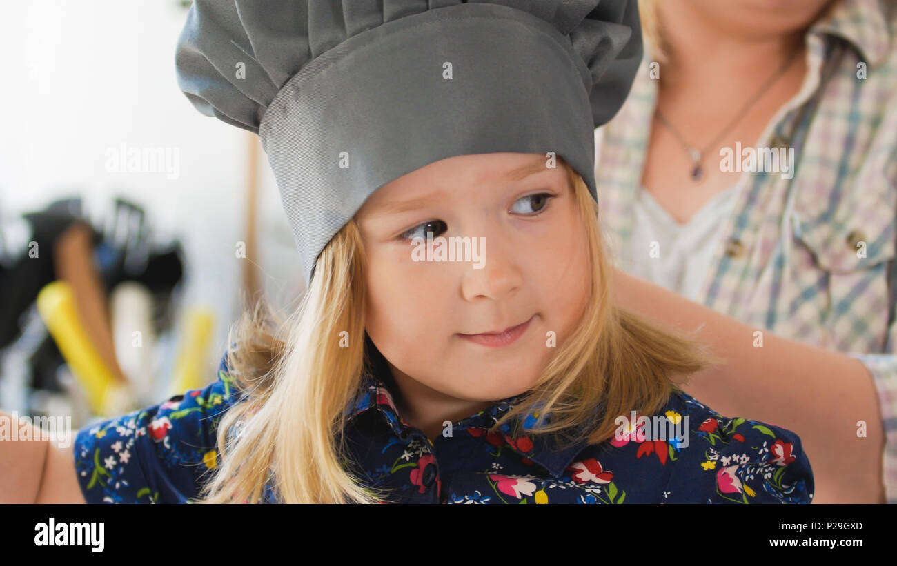 Cute little girl chef in hat smiling at cooking studio Stock Photo - Alamy