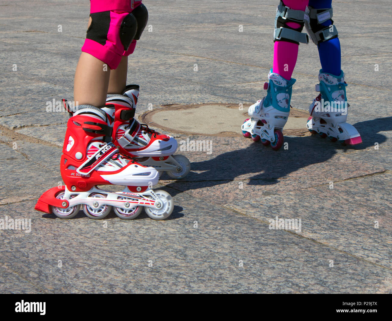 Roller skates on two little girls feet, training in roller skating ...