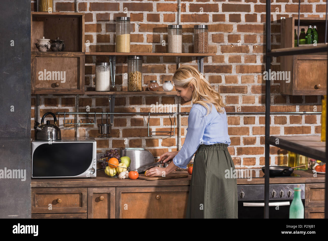 side view of woman preparing at kitchen Stock Photo - Alamy