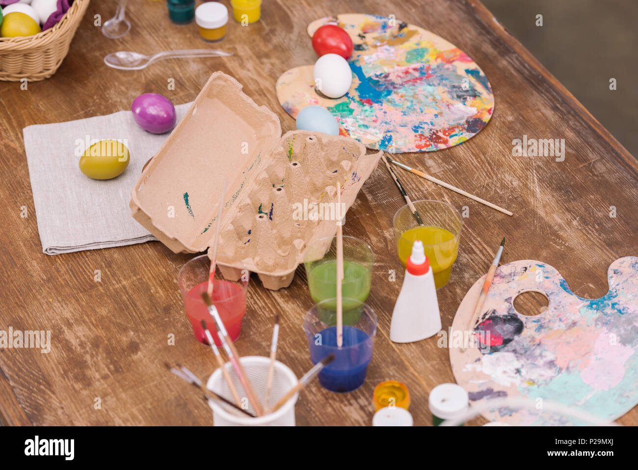 empty egg tray and painted chicken eggs for easter on table Stock Photo ...