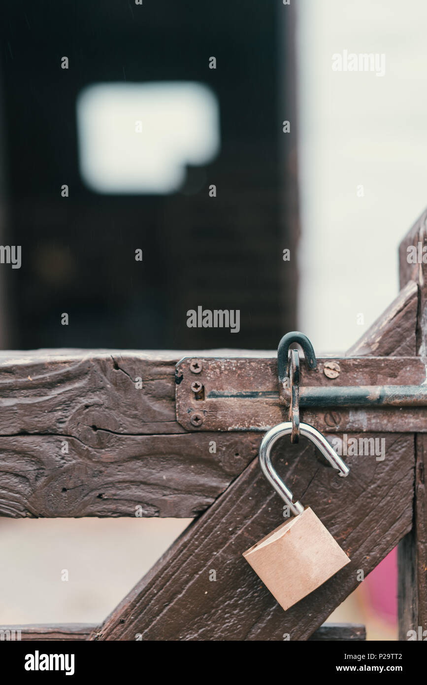 Wooden gates with unlocked padlock to the barn and anmial enclosure on ...