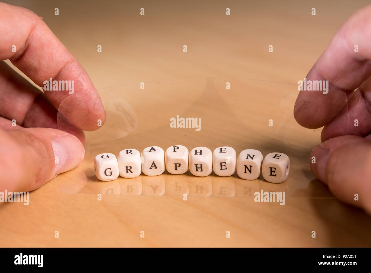 Graphene word in wooden letters and mans's hands with a transparent and ...