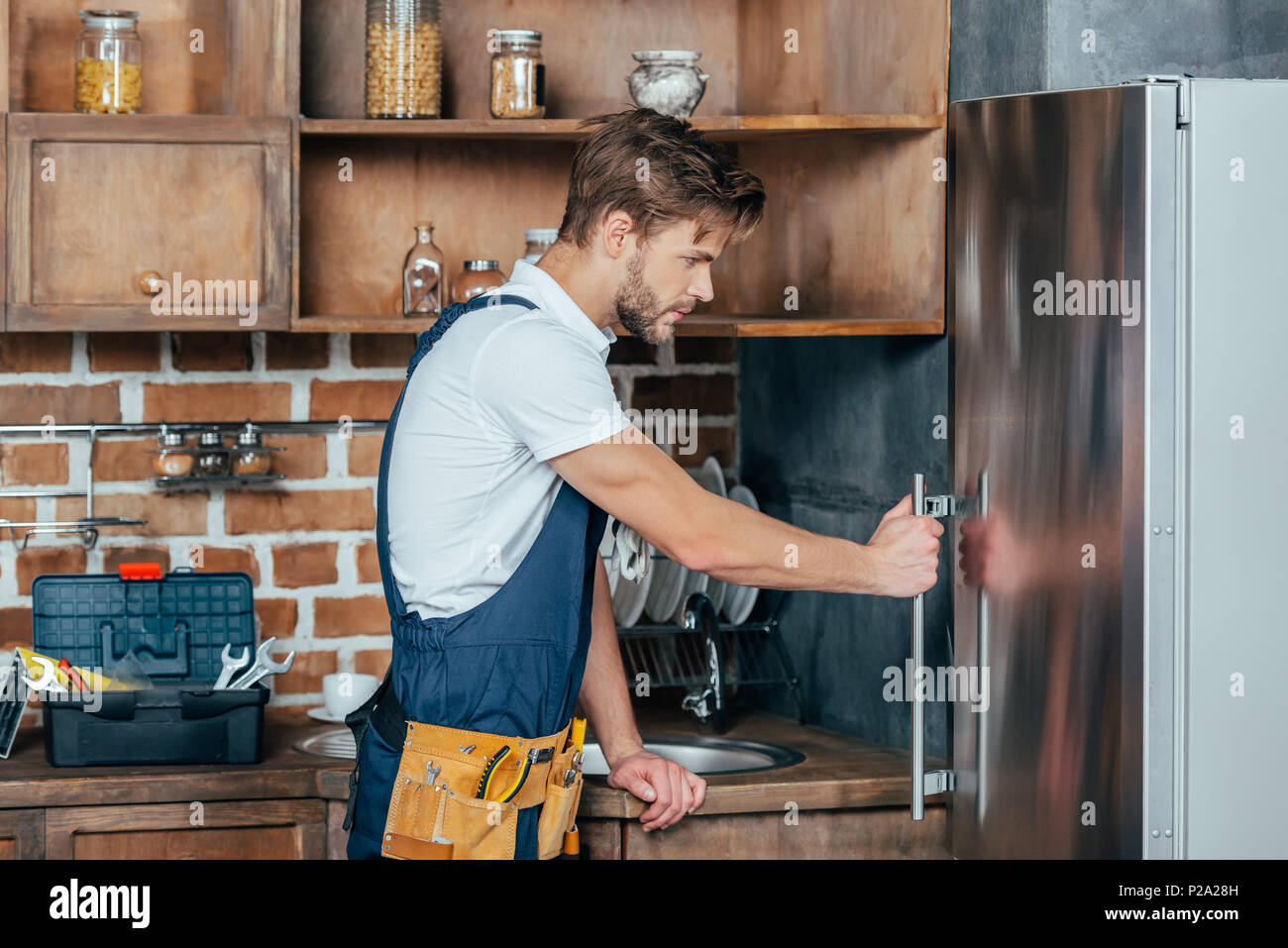 Male repairman fixing refrigerator hi-res stock photography and images ...