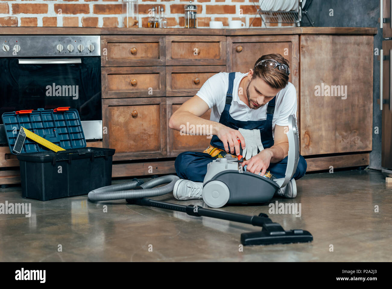 professional repairman fixing vacuum cleaner Stock Photo - Alamy