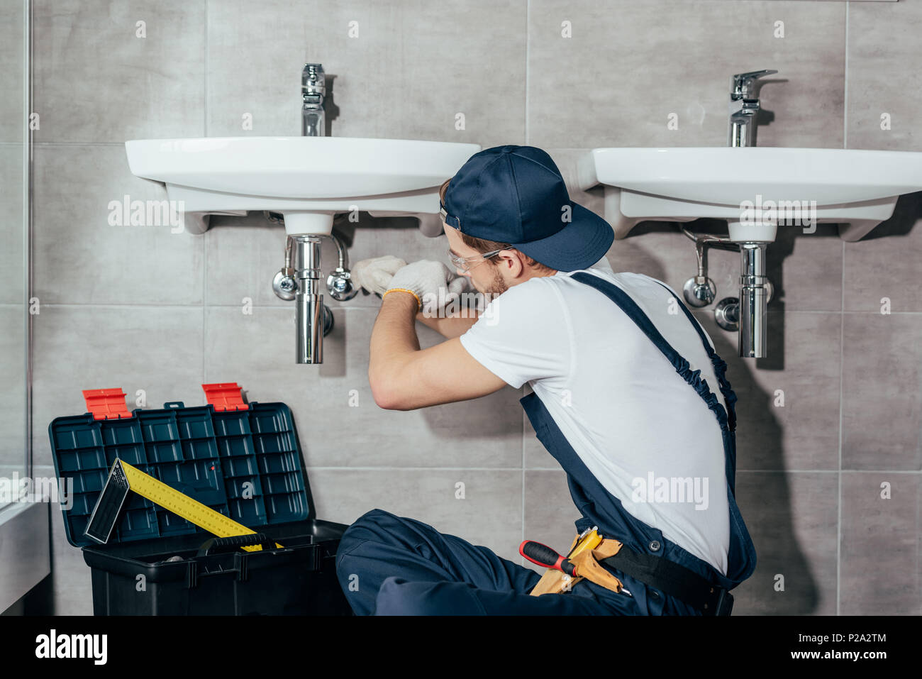 Young handyman fixing sink hi-res stock photography and images - Alamy
