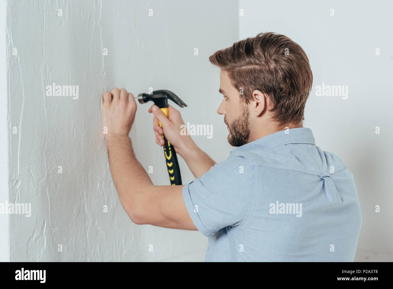 Handyman hammering nail in wall hi-res stock photography and images - Alamy