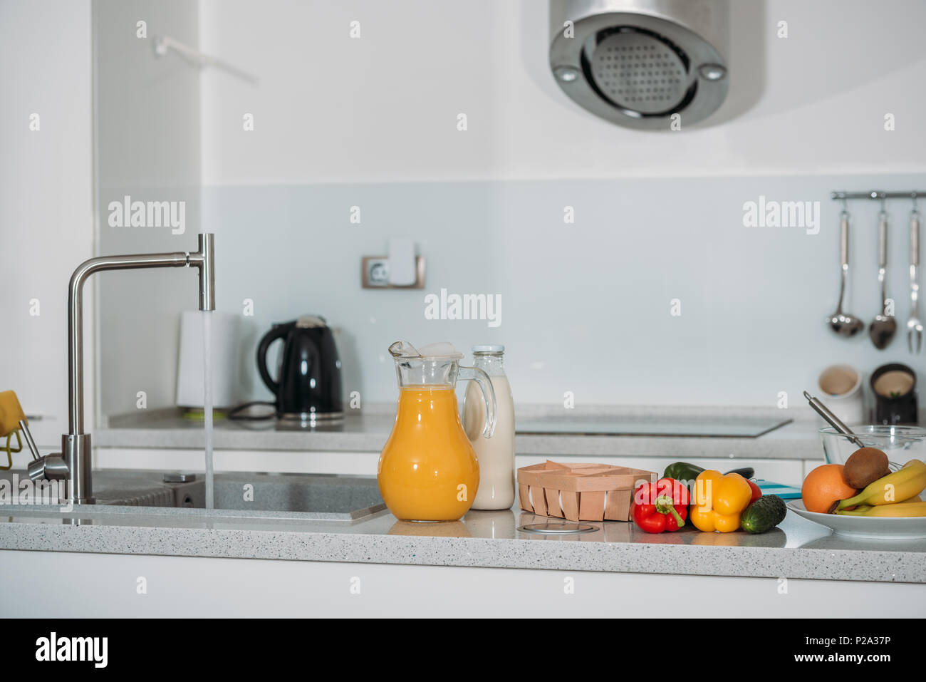fruits, vegetables and orange juice with milk on kitchen table Stock ...