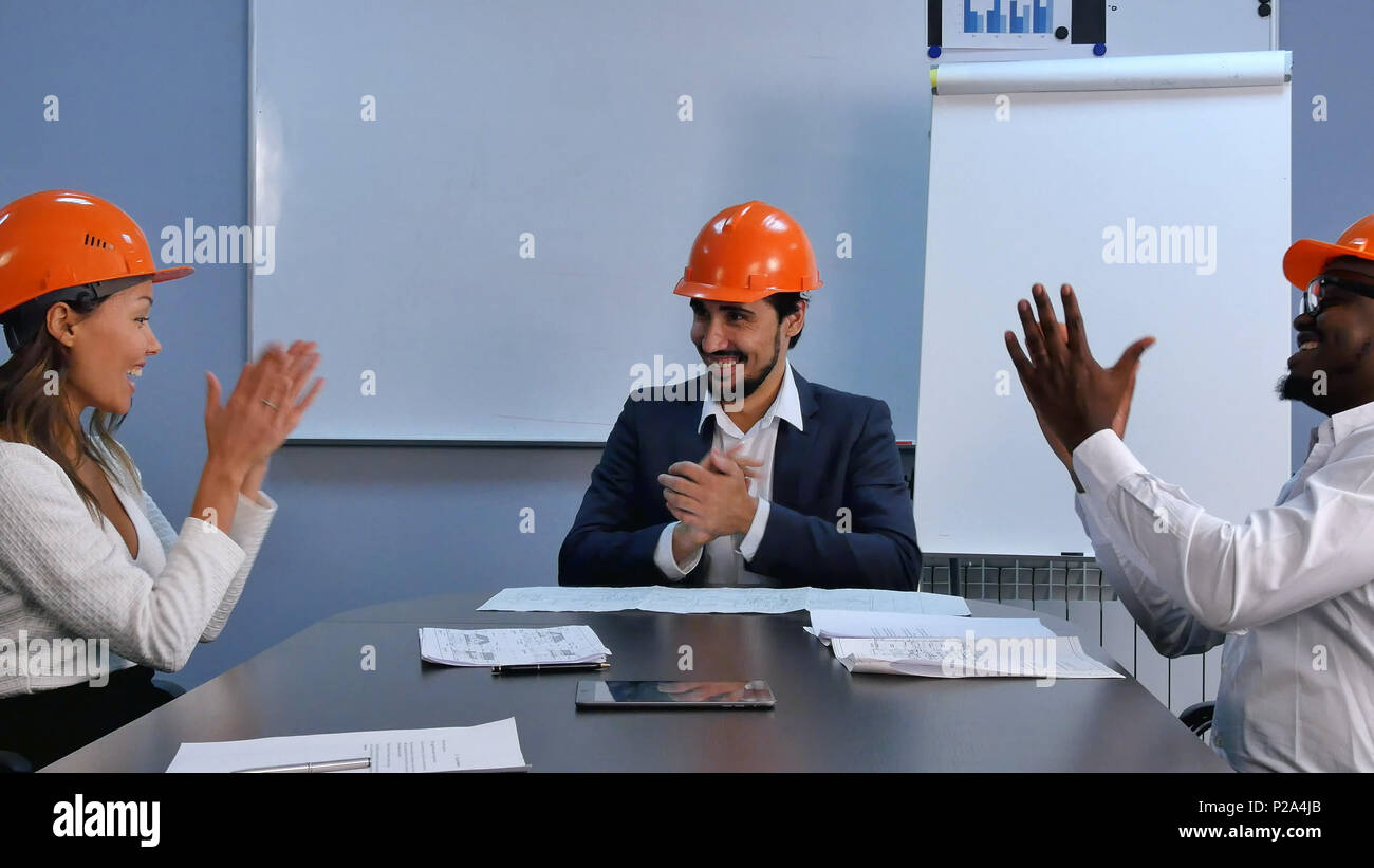 Successful in business multiracial team of engineers celebrating ...