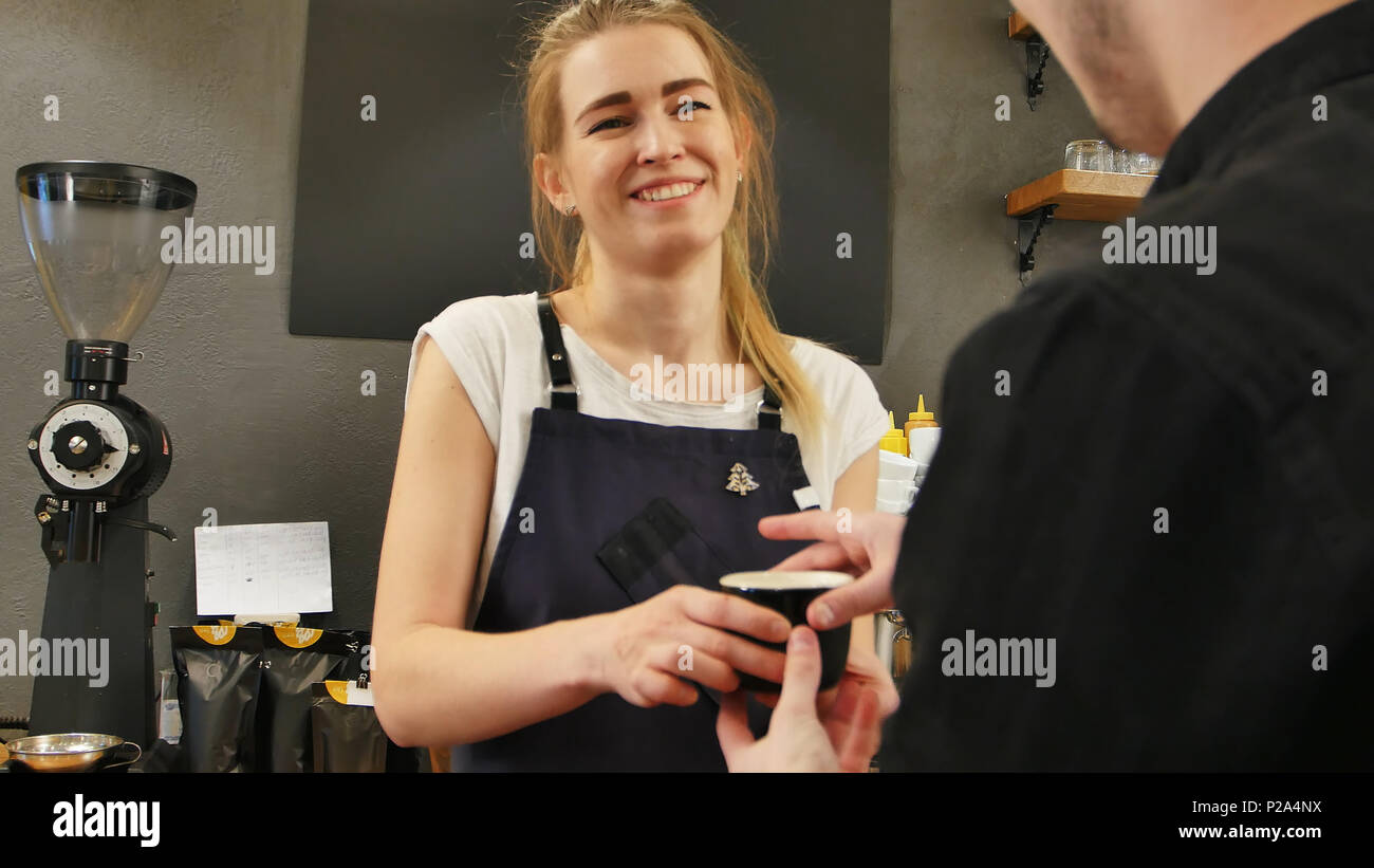 Waitress serving customer over the counter at a coffee shop Stock Photo ...