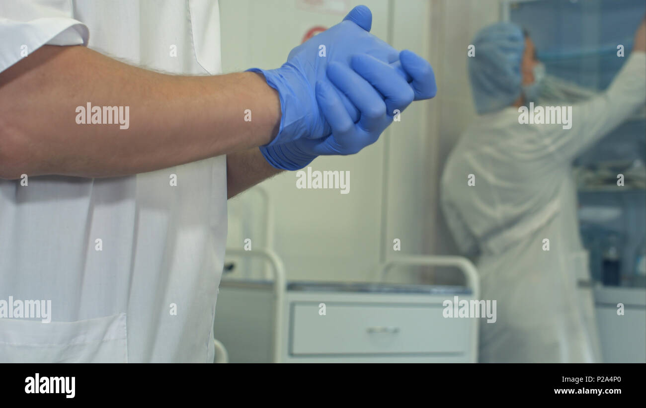 Surgeon putting on sterile rubber gloves for surgical operation Stock ...