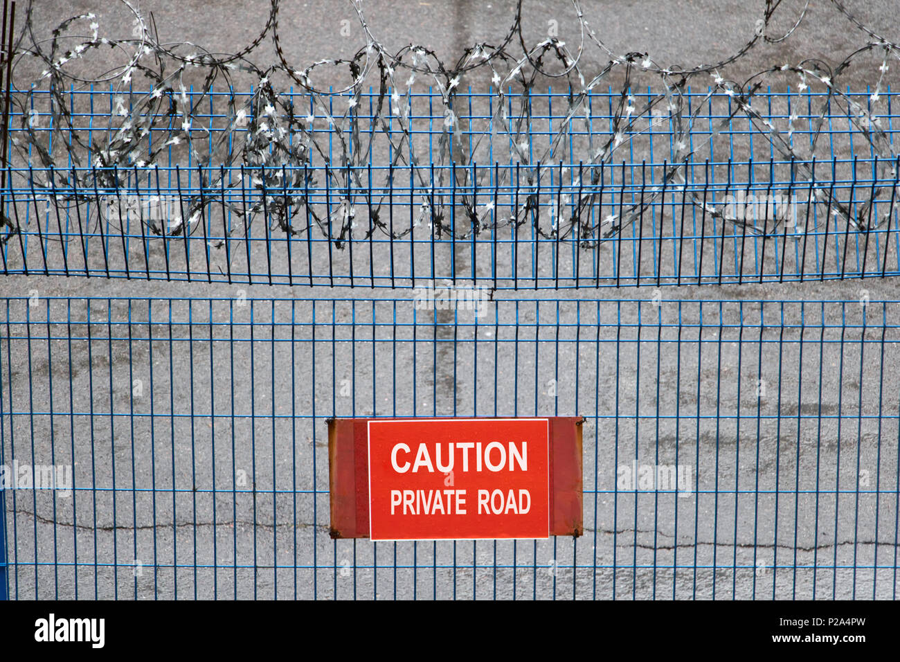 Iron fence with barbed wire. Metallic fence with red warning sign ...