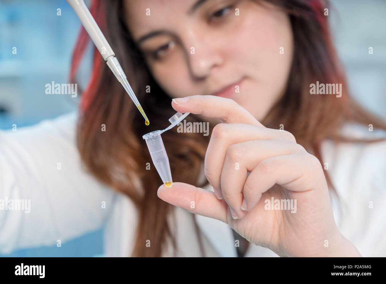 Woman technician with multipipette in genetic laboratory PCR research ...