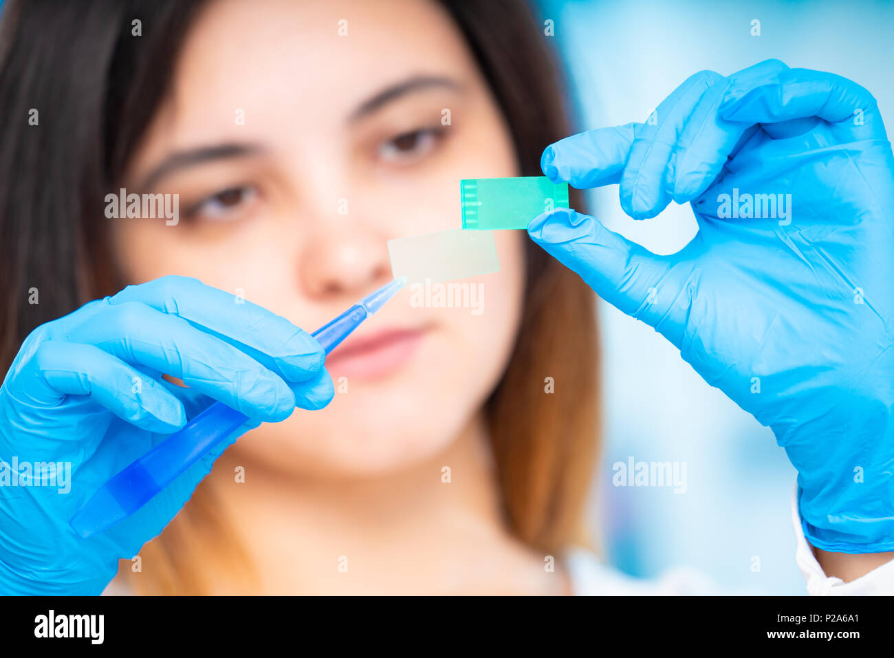 technician girl with microfluidic device LOC in microbiological lab ...
