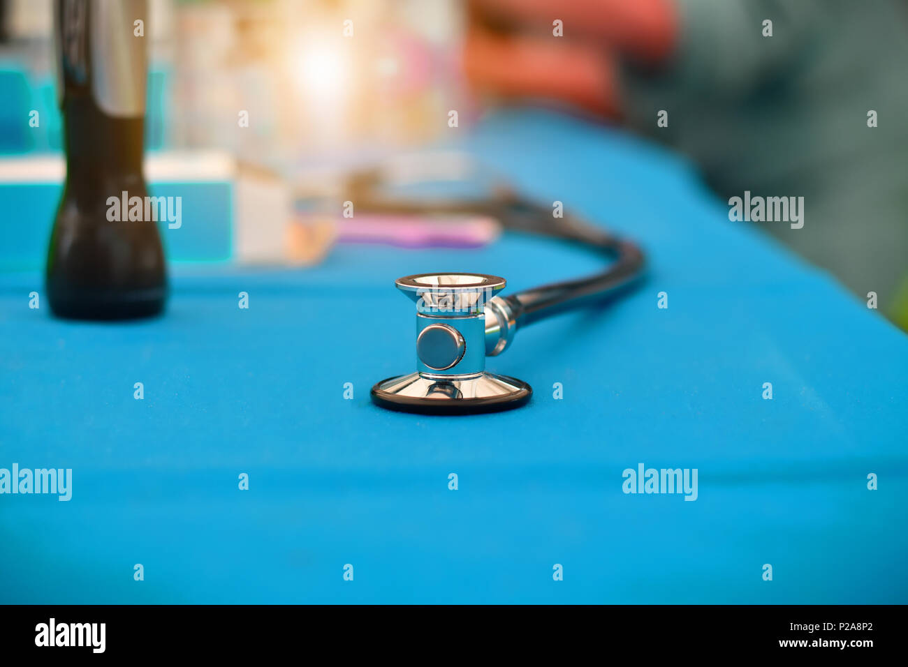 The stethoscope is placed on a blue table and there is a doctor in the ...