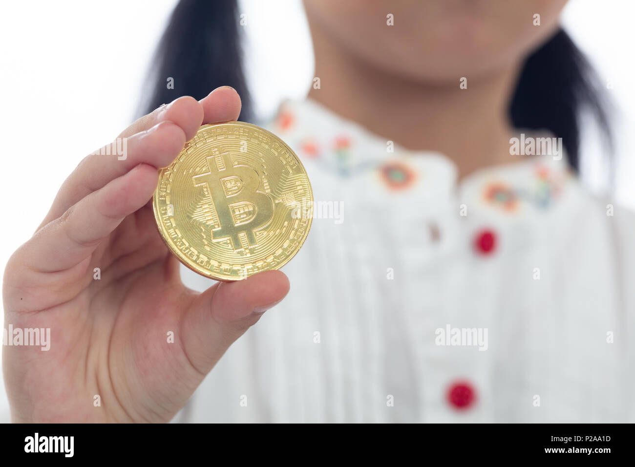 Children's hand holding golden Bitcoin in isolated white background ...