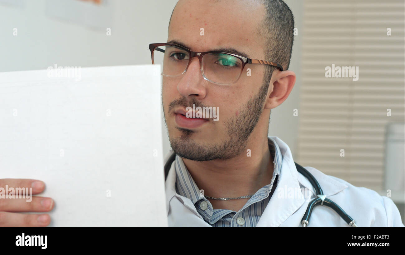 Serious doctor checking important medical analysis Stock Photo - Alamy
