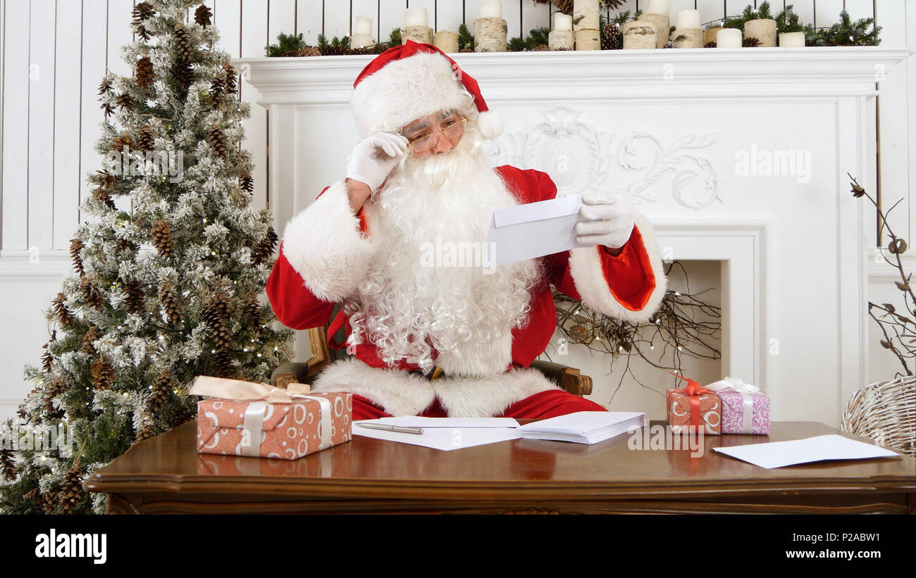 Santa Claus sorting out paper letters from children Stock Photo - Alamy