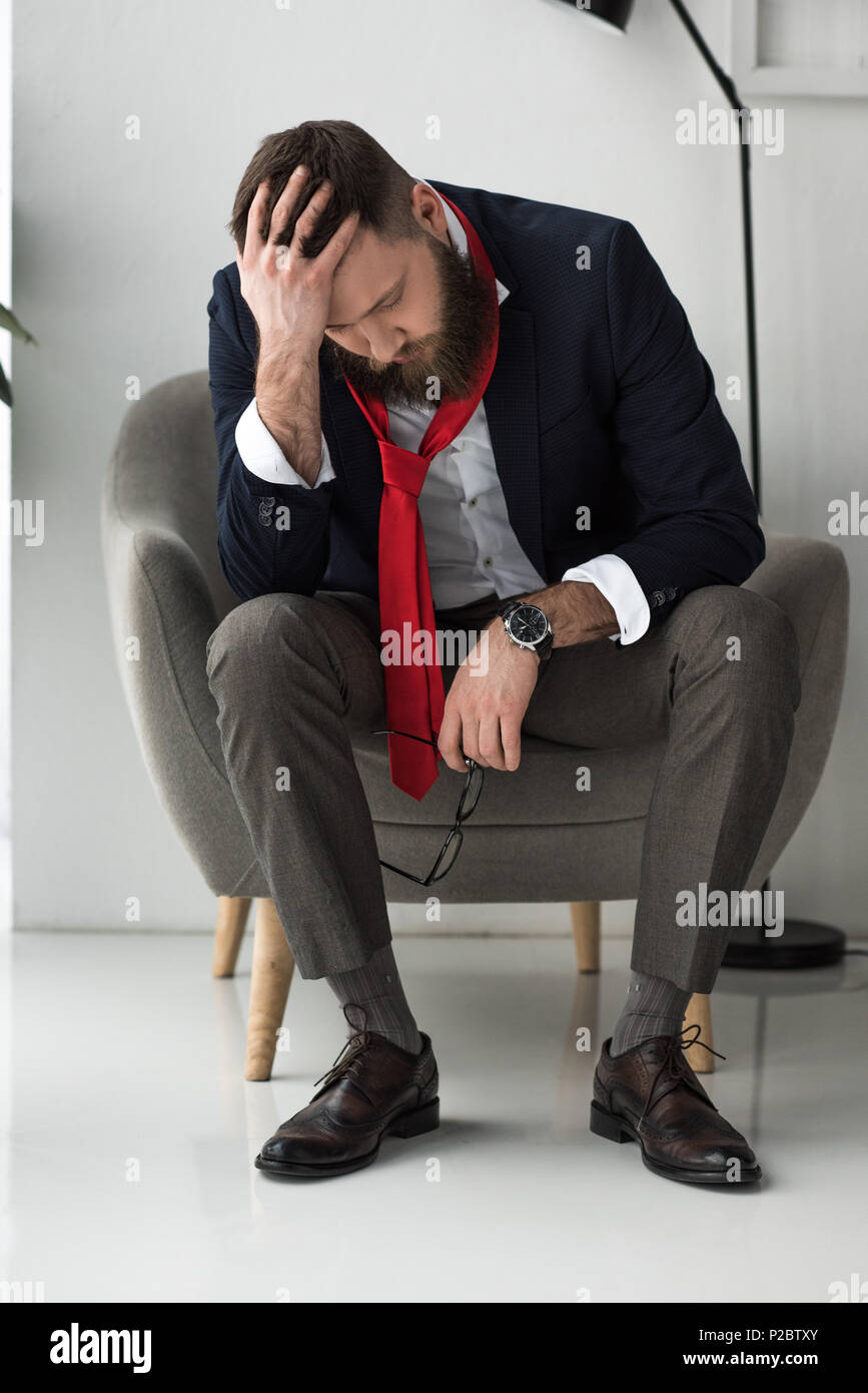 overworked businessman in stylish suit sitting in armchair Stock Photo ...