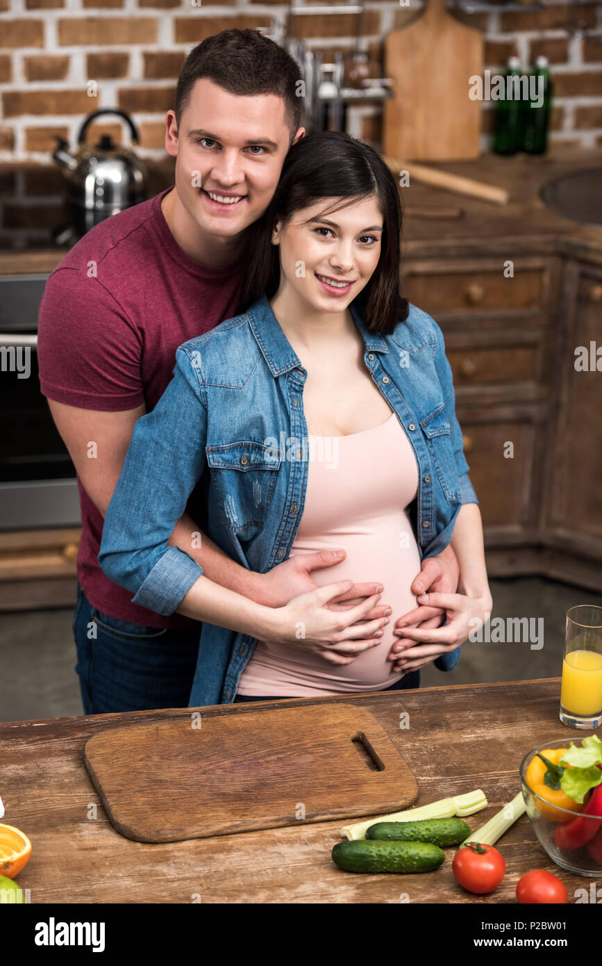 Happy young pregnant couple hugging hi-res stock photography and images ...