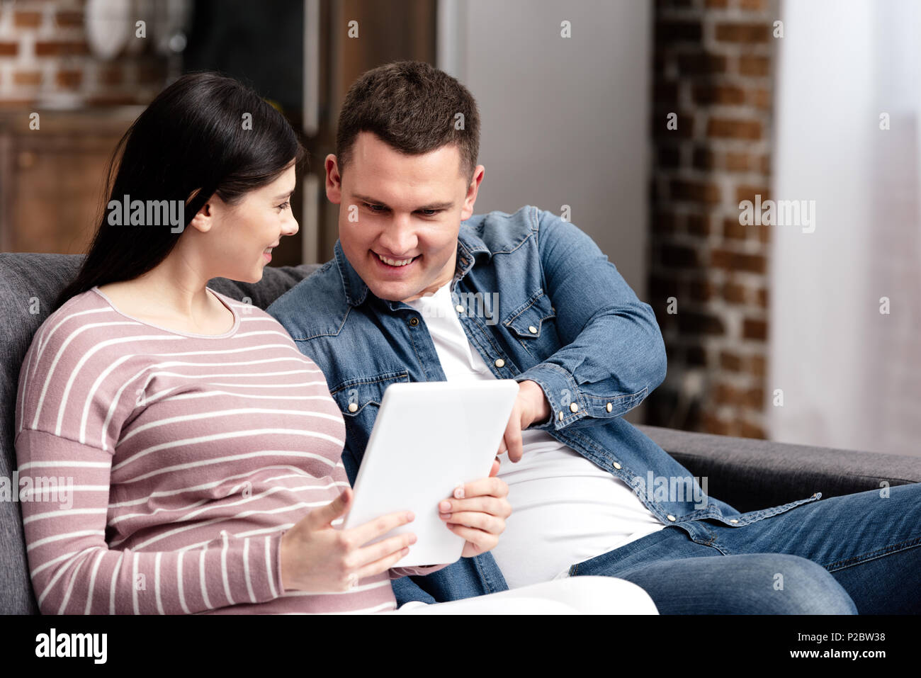 Happy pregnant couple tablet hi-res stock photography and images - Alamy