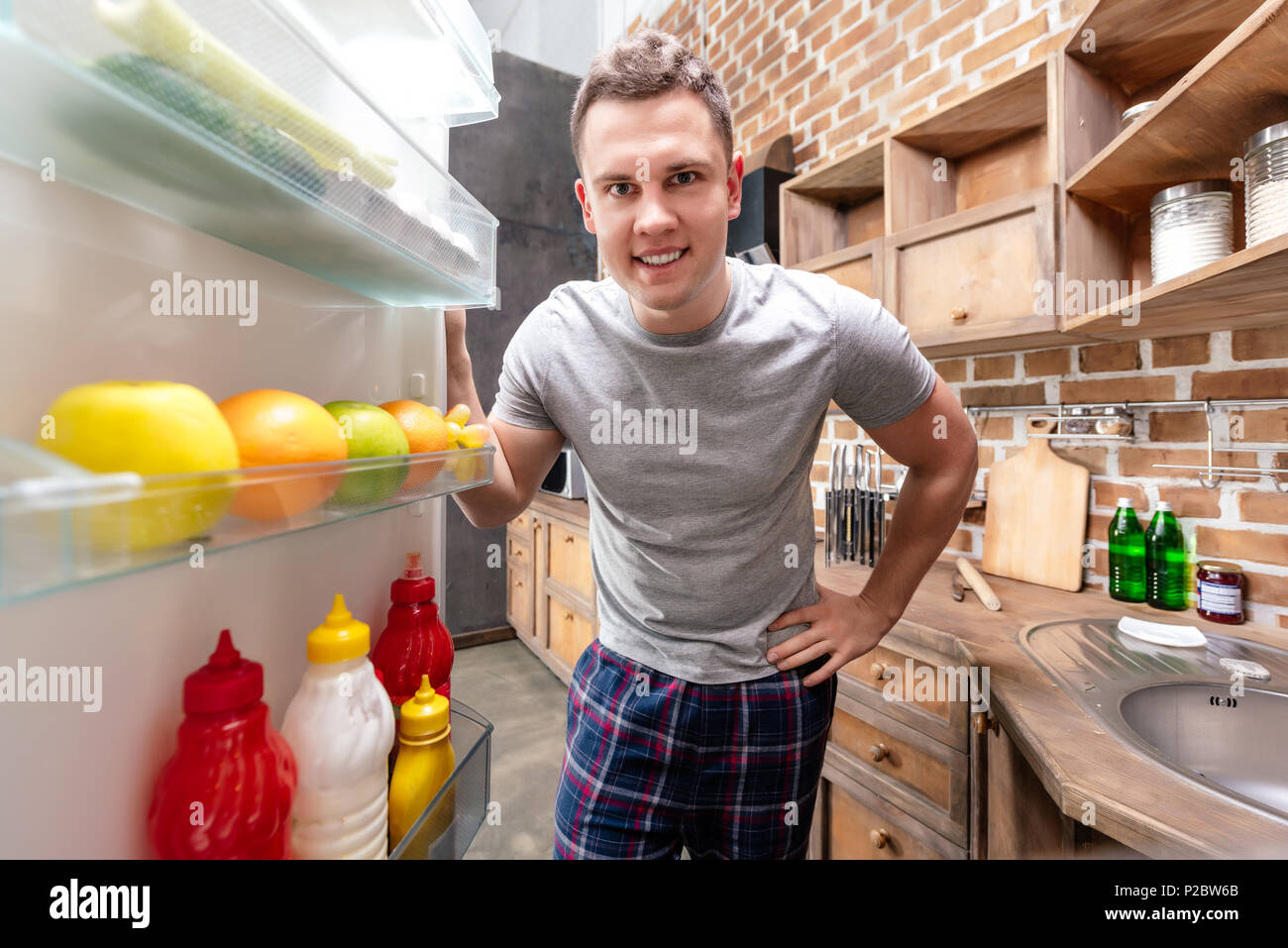 Young man looking inside fridge hi-res stock photography and images - Alamy