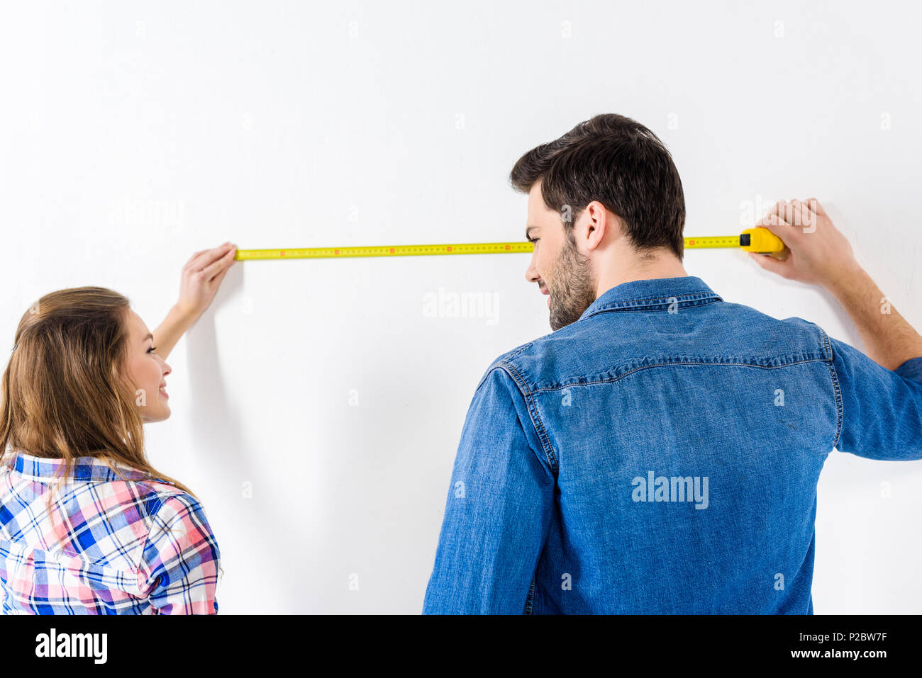 girlfriend and boyfriend measuring wall with tape measure Stock Photo ...