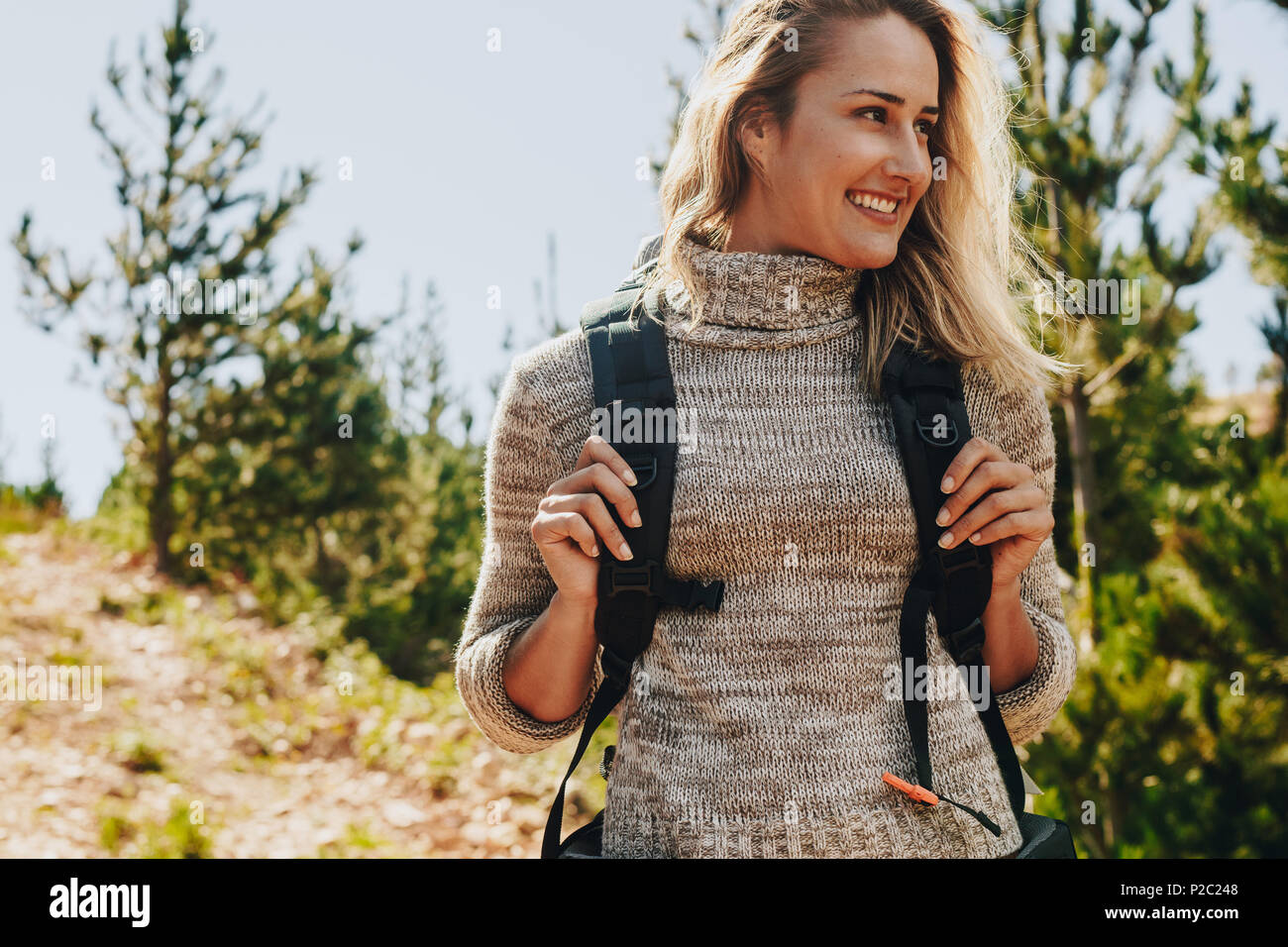 Attractive caucasian woman with backpack walking down the mountain ...