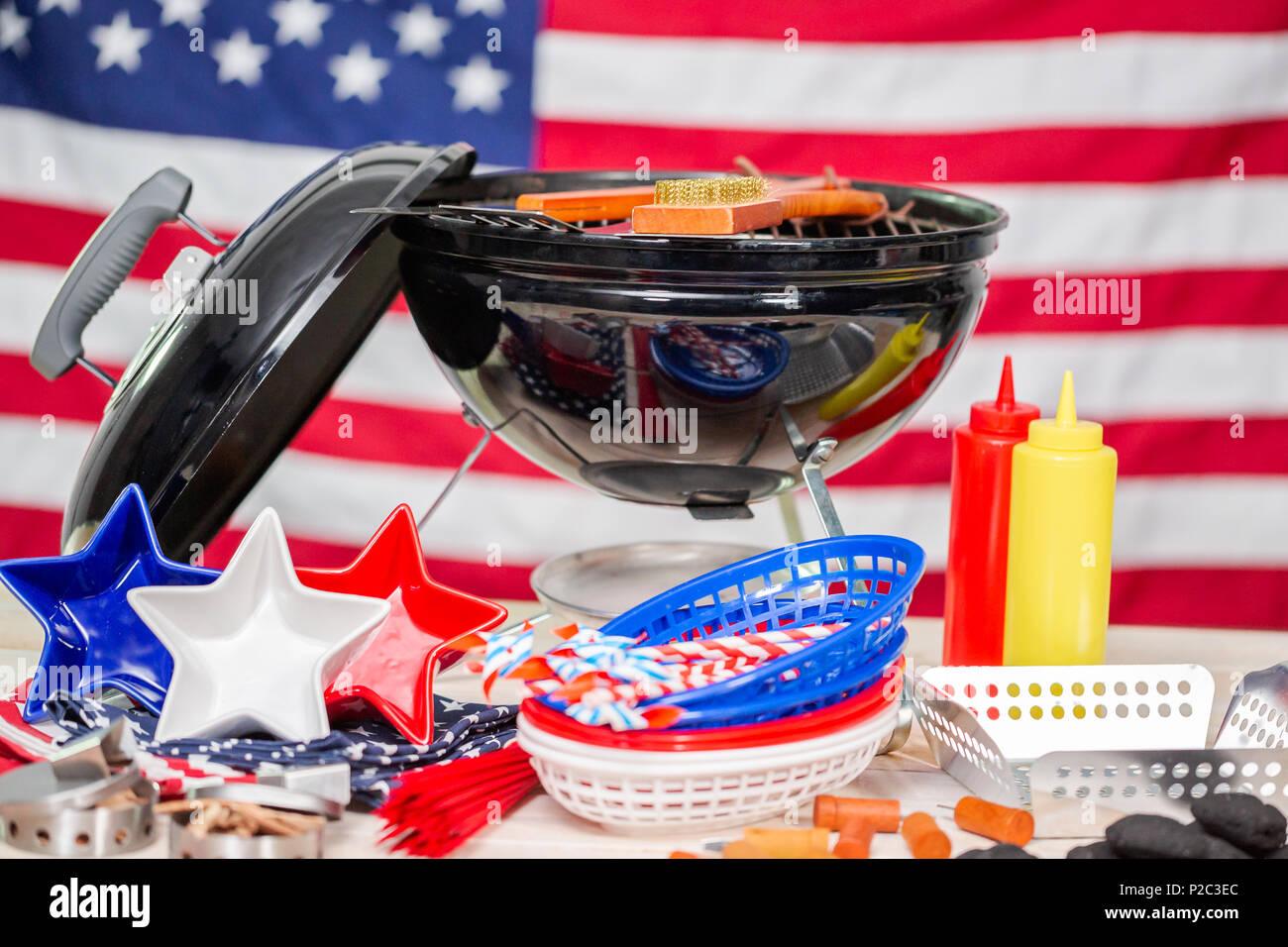 Small round charcoal grill and July 4th decorations on American flag ...