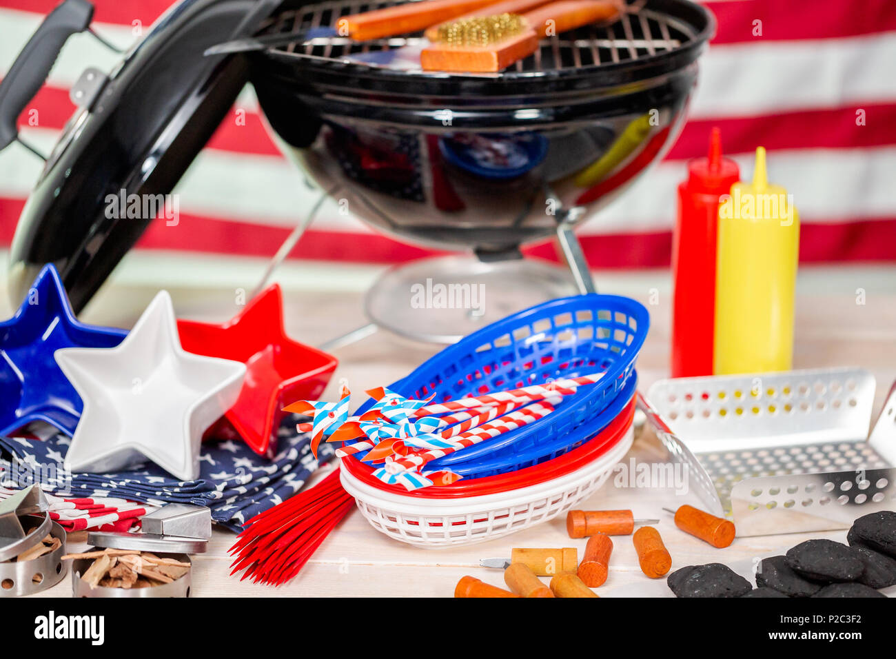 Small round charcoal grill and July 4th decorations on American flag ...