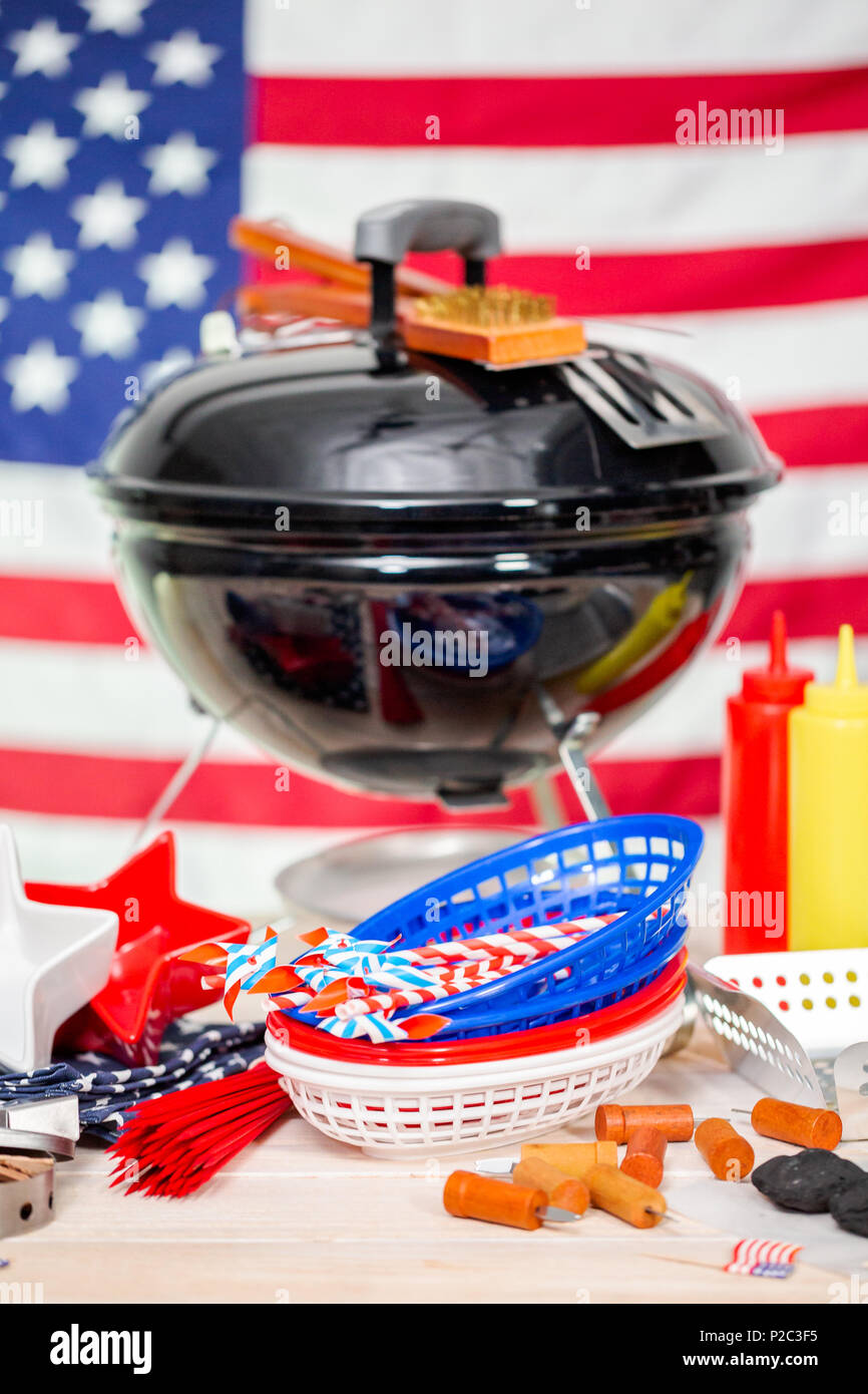 Small round charcoal grill and July 4th decorations on American flag ...