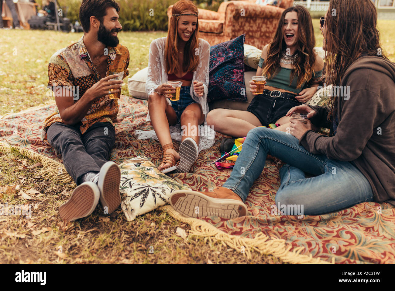 Cheerful young friends hanging out with beers. Group of friends sitting ...