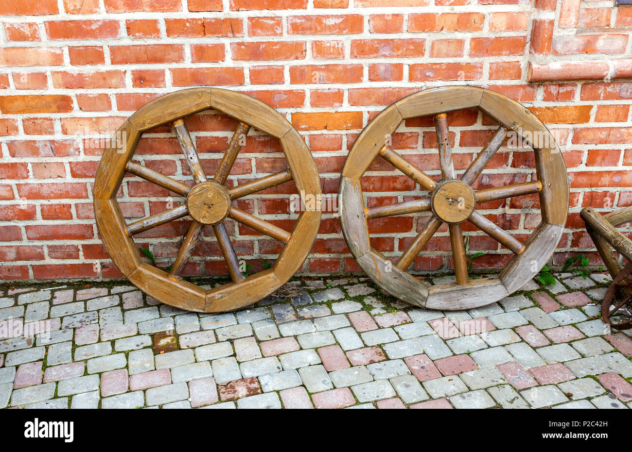 Old wooden wagon wheels near the brick wall Stock Photo - Alamy