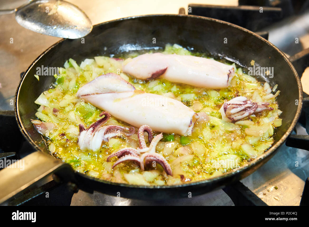 Baby squid cooked with onions Stock Photo - Alamy